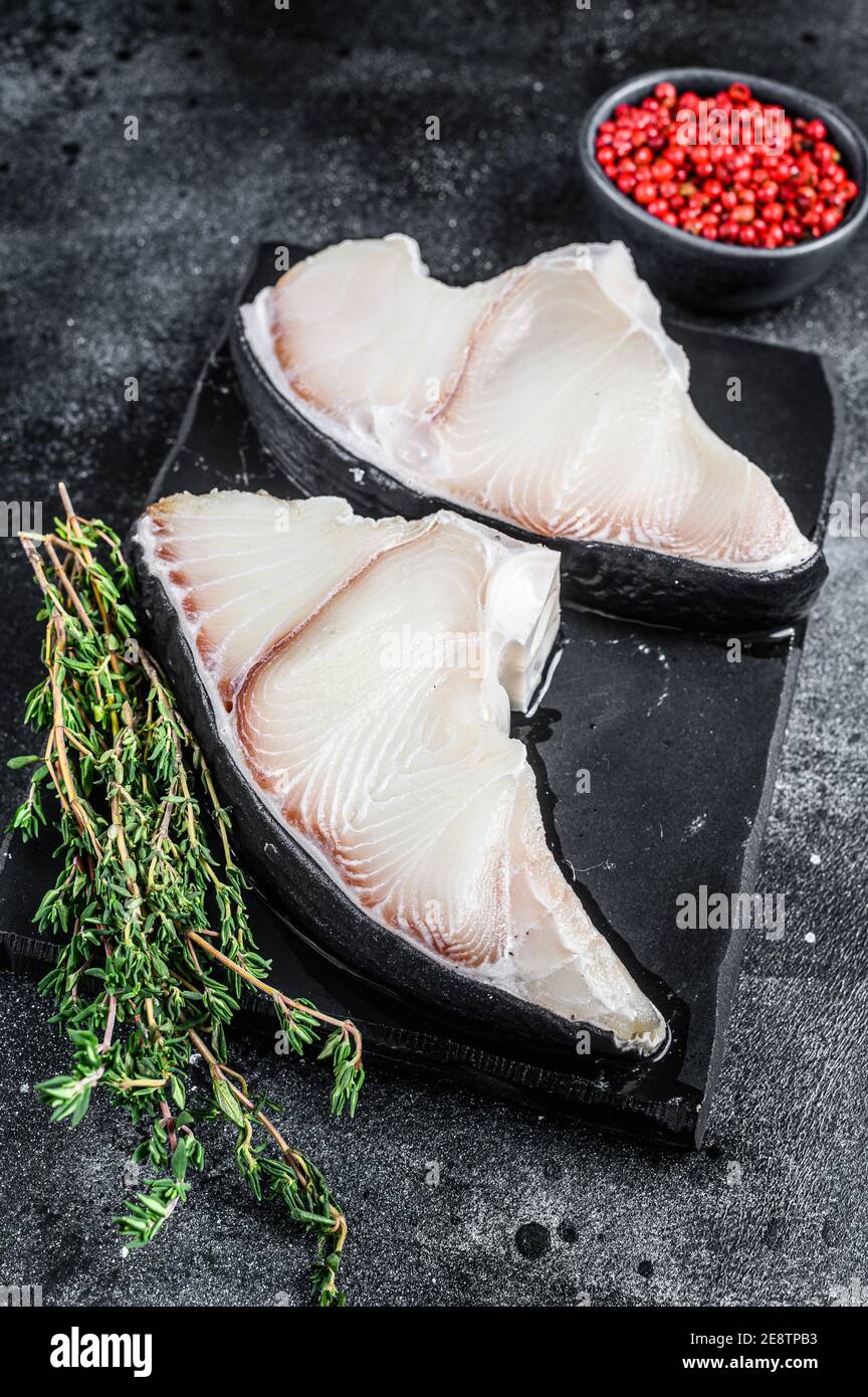 Raw Shark fish steaks on a board. Black background. Top view Stock ...