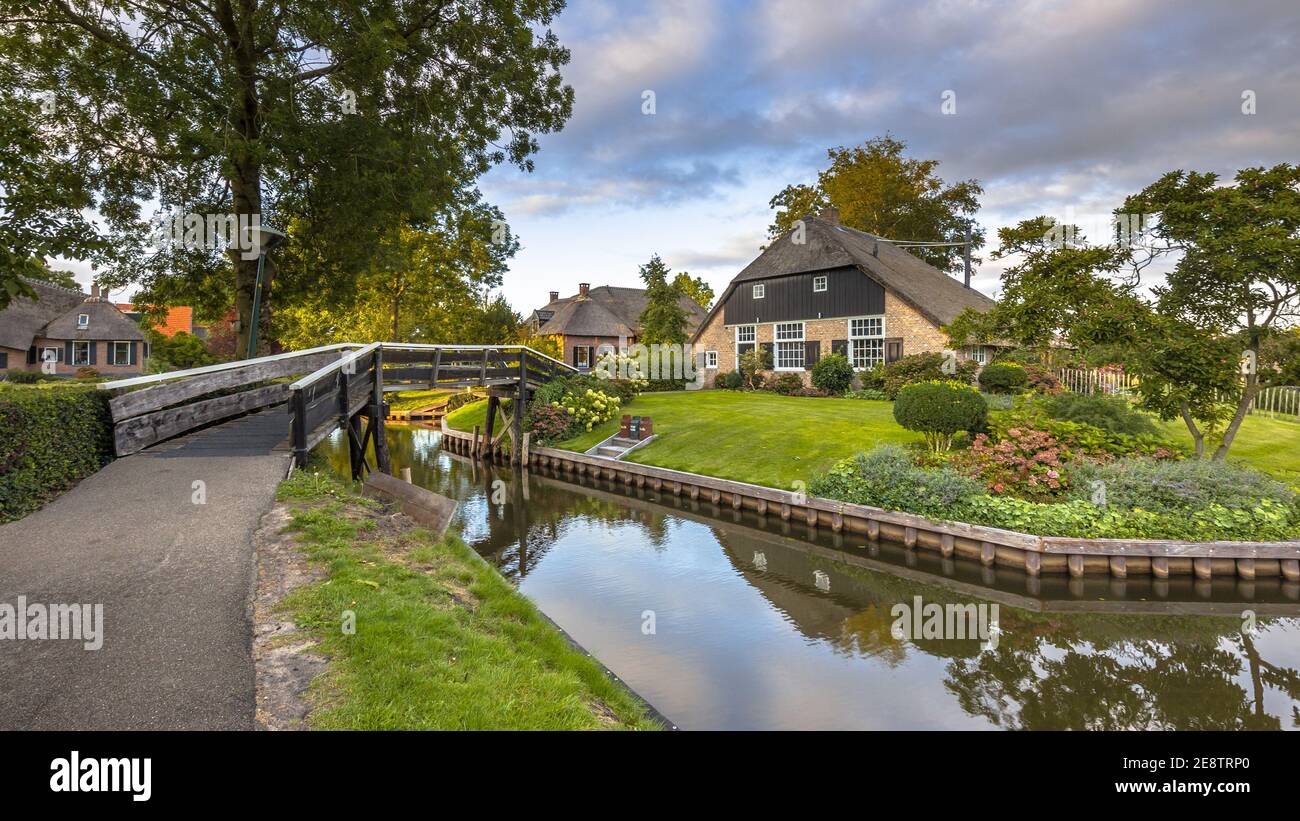 Landscape view of famous Giethoorn village with canals and rustic thatched roof houses in farm ...