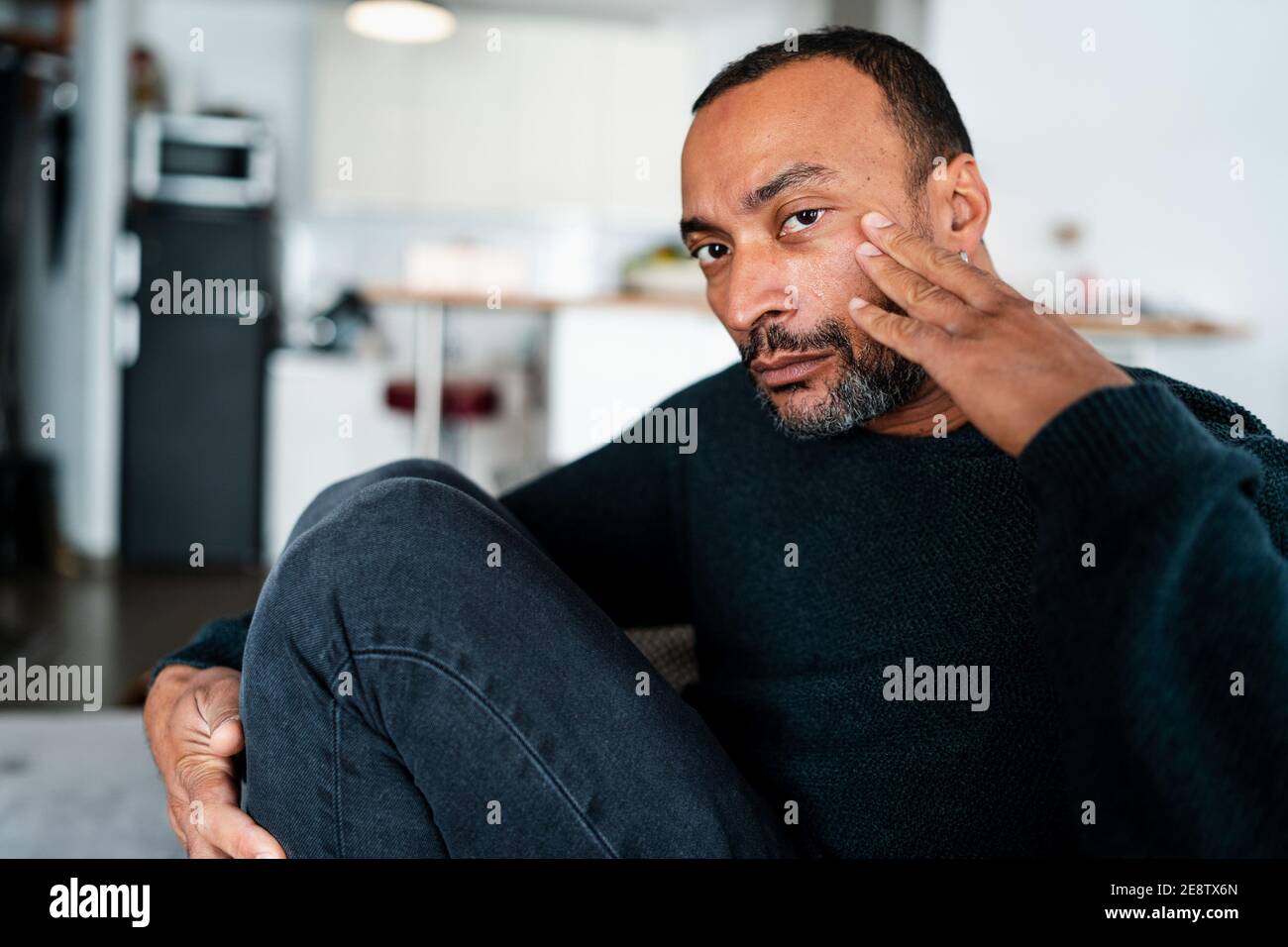 Sad 40 years old man sitting on the sofa at home Stock Photo - Alamy