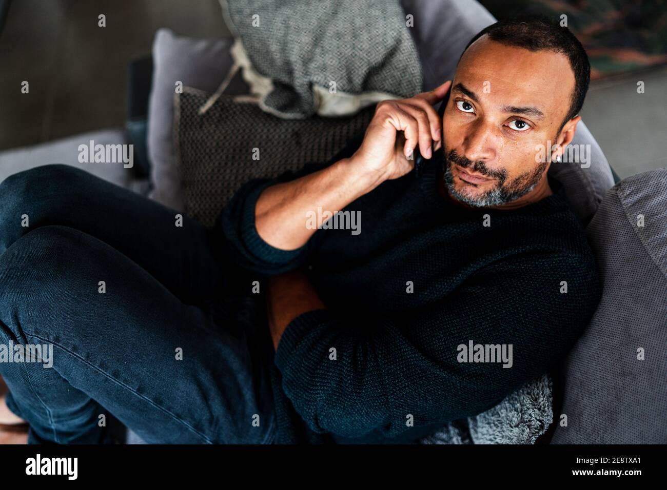 Sad man talking on the phone at home Stock Photo - Alamy