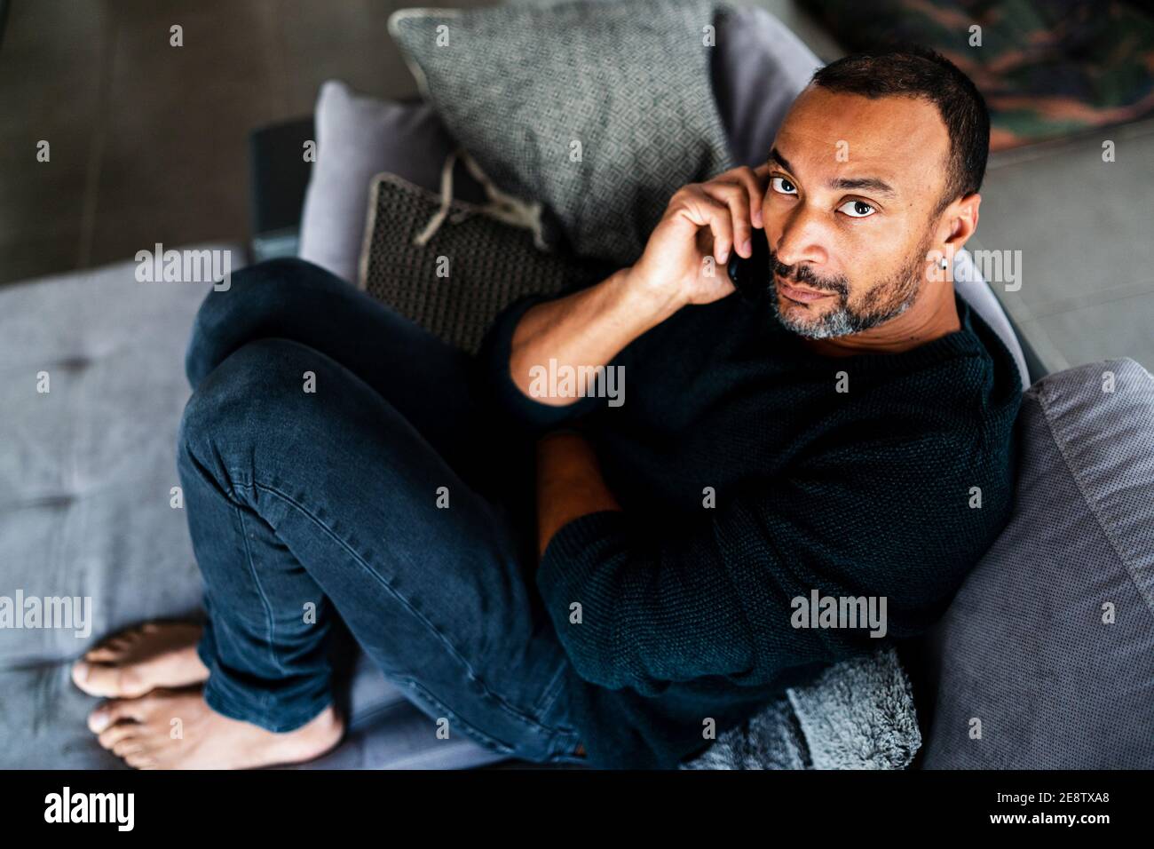Sad man talking on the phone at home Stock Photo - Alamy