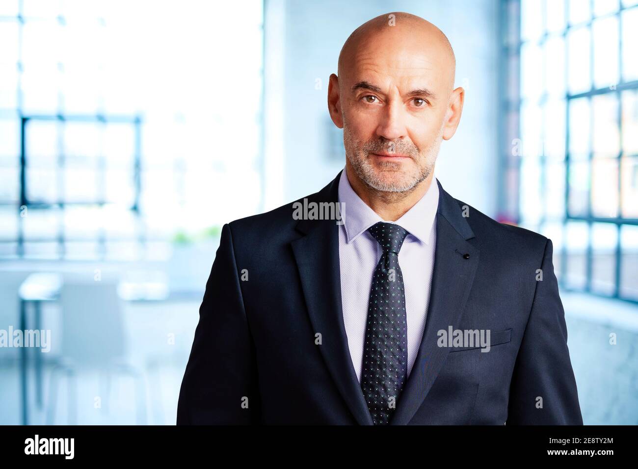 Portrait shot of serious faced businessman standing in meeting room ...