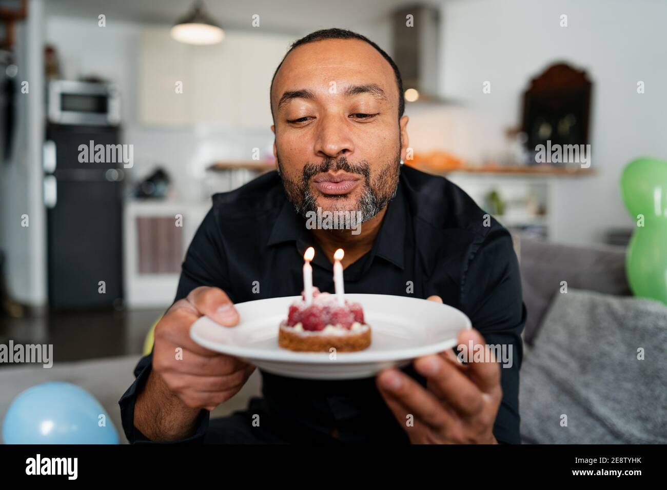 Handsome 40 years old man blowing candles on his birthday cake Stock ...
