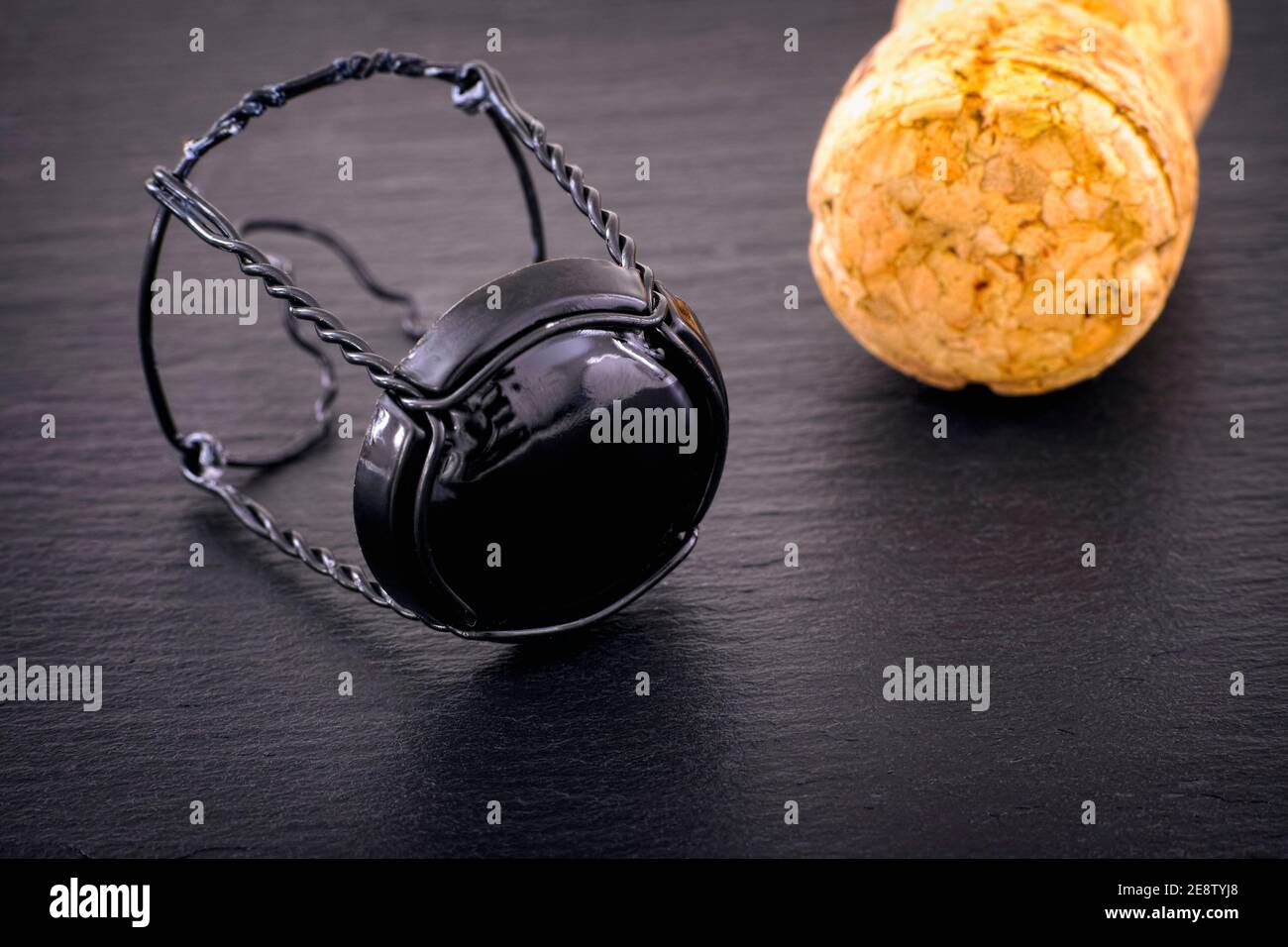 Champagne muselet with black cap and cork on black stone background ...