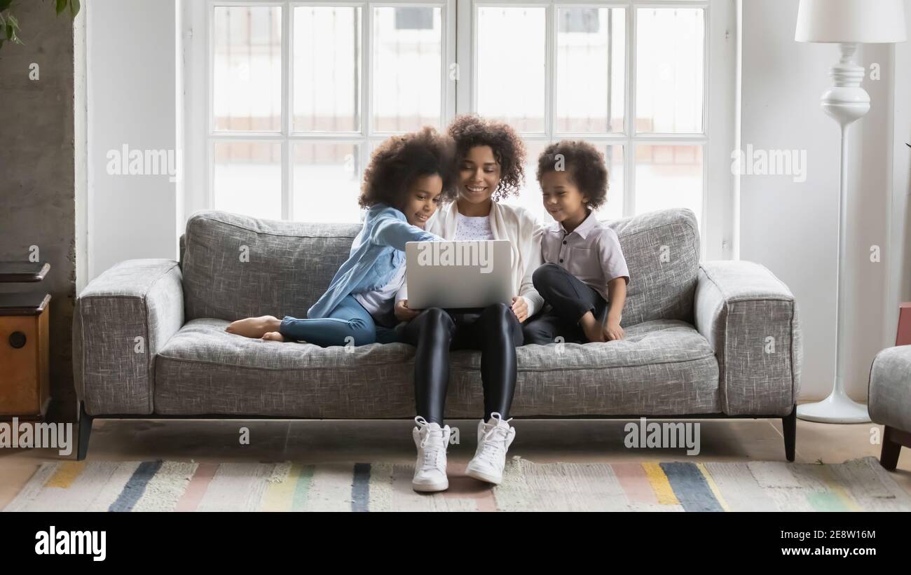 Happy African American woman with kids using laptop at home Stock Photo ...