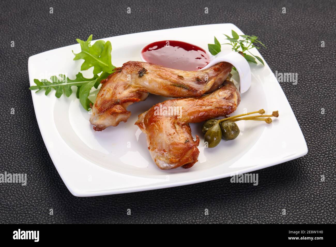 Roasted rabbit legs with cowberry sauce Stock Photo - Alamy
