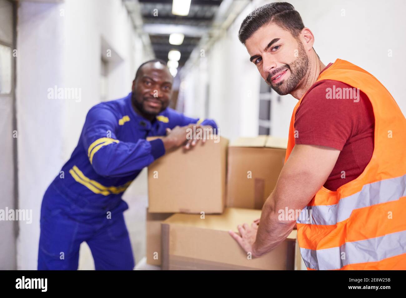 Two warehouse workers from the forwarding company transport packages to ...