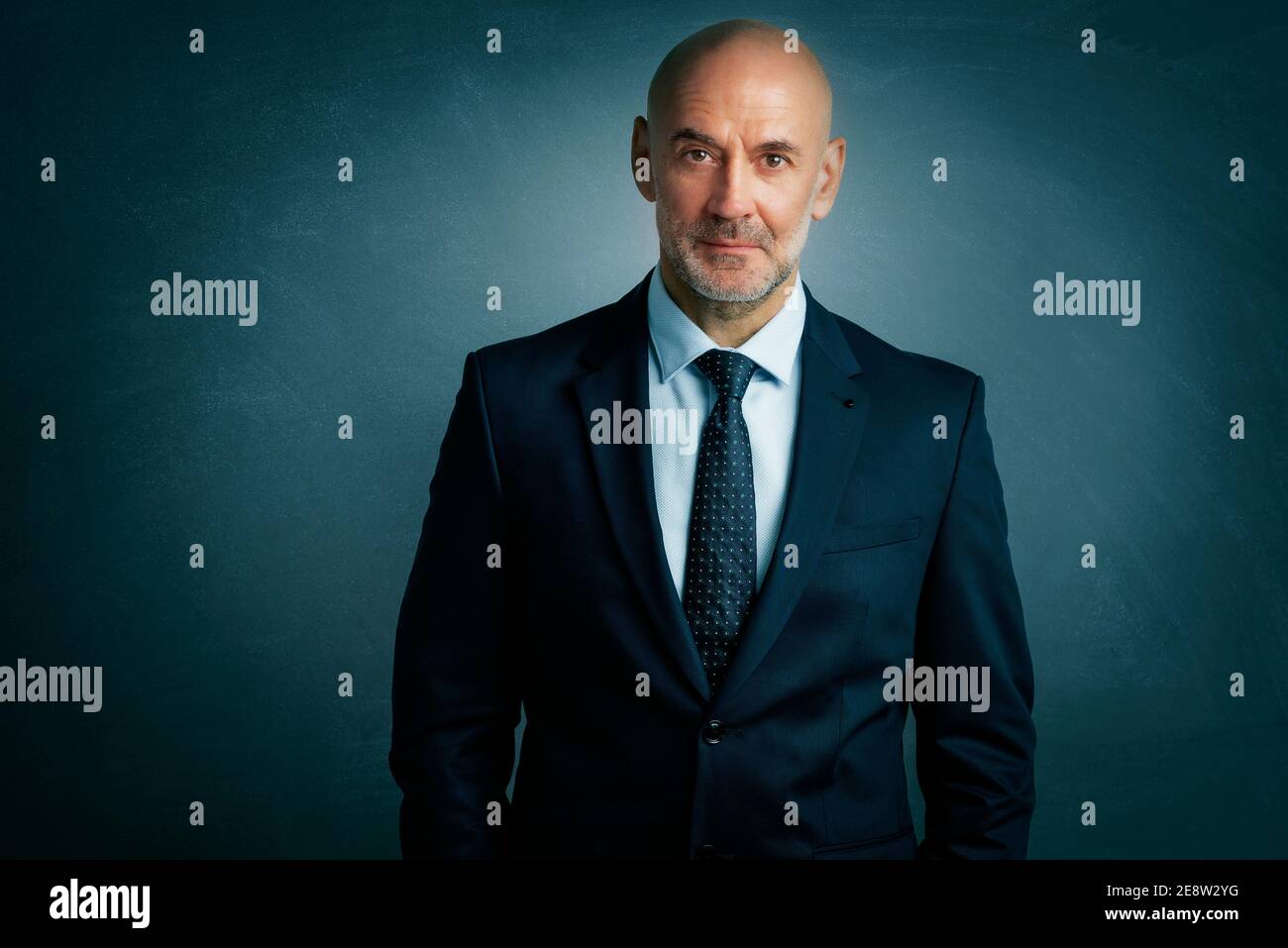 Portrait of serious faced businessman standing against at isolated ...