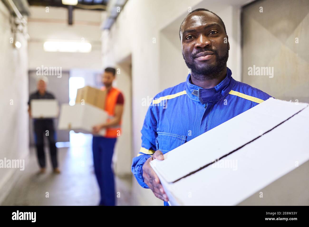 African worker as a mini jobber carries cardboard boxes to the ...
