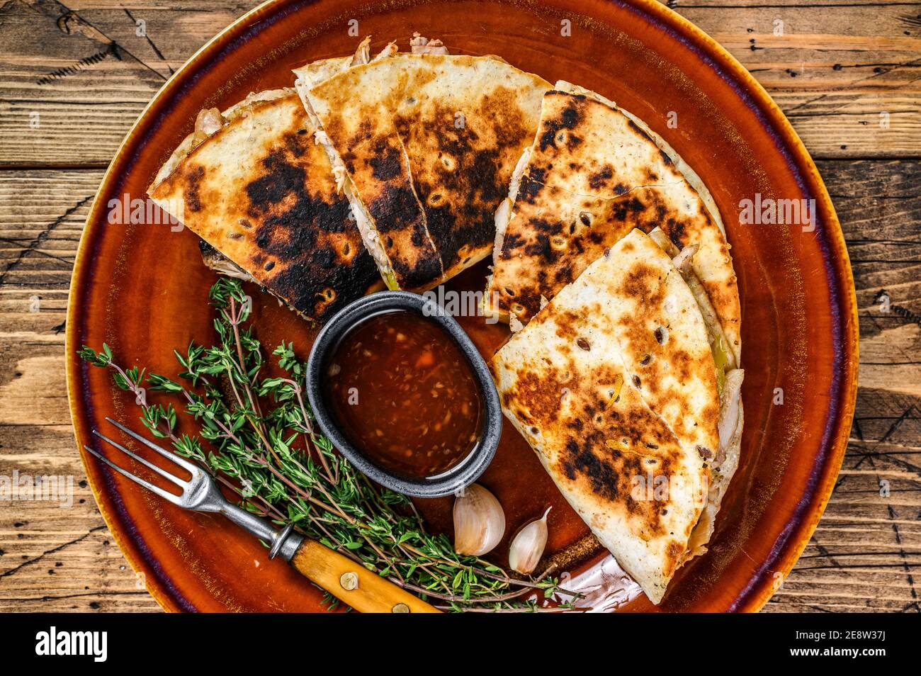 Mexican quesadilla with chicken, paprika, cheese and cilantro on wooden ...