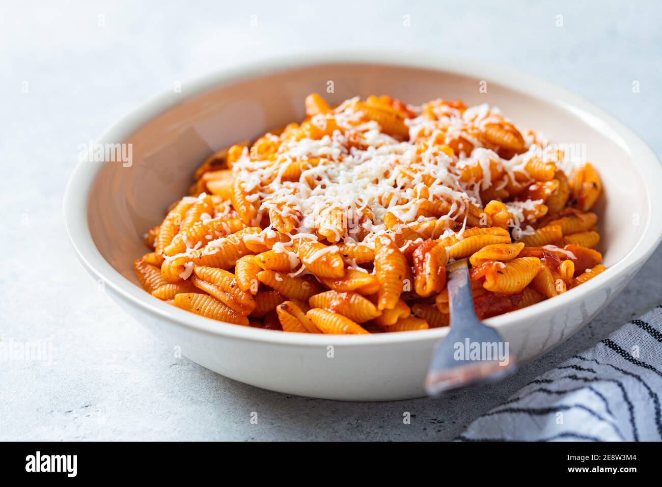 Gnocchetti sardi pasta in tomato sauce with cheese, gray background ...