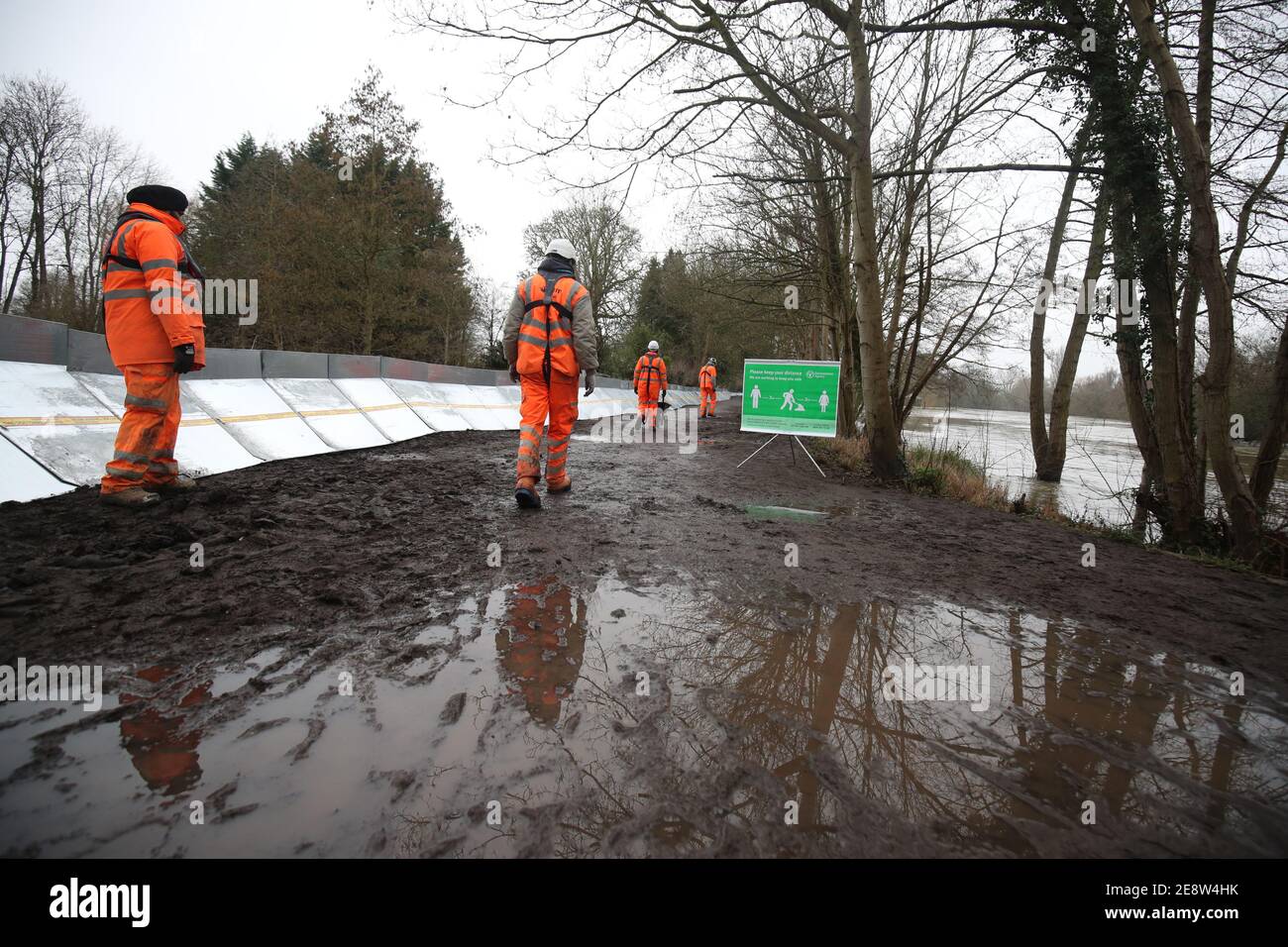 Workers at the temporary barrier in Weybridge, Surrey, after Storm ...