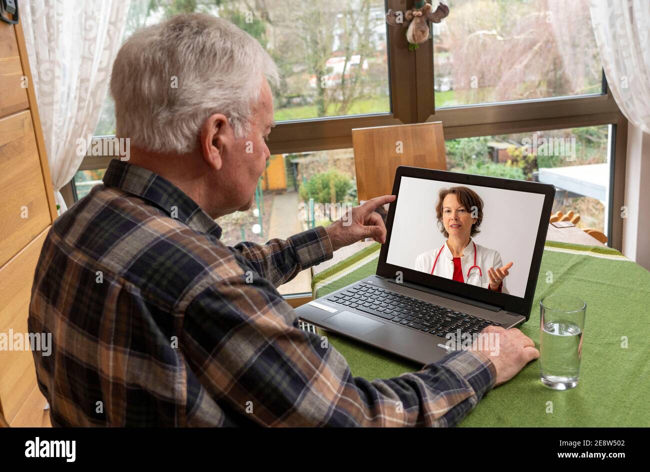 Symbolic image of telemedicine, elderly patient talks to a doctor in a ...