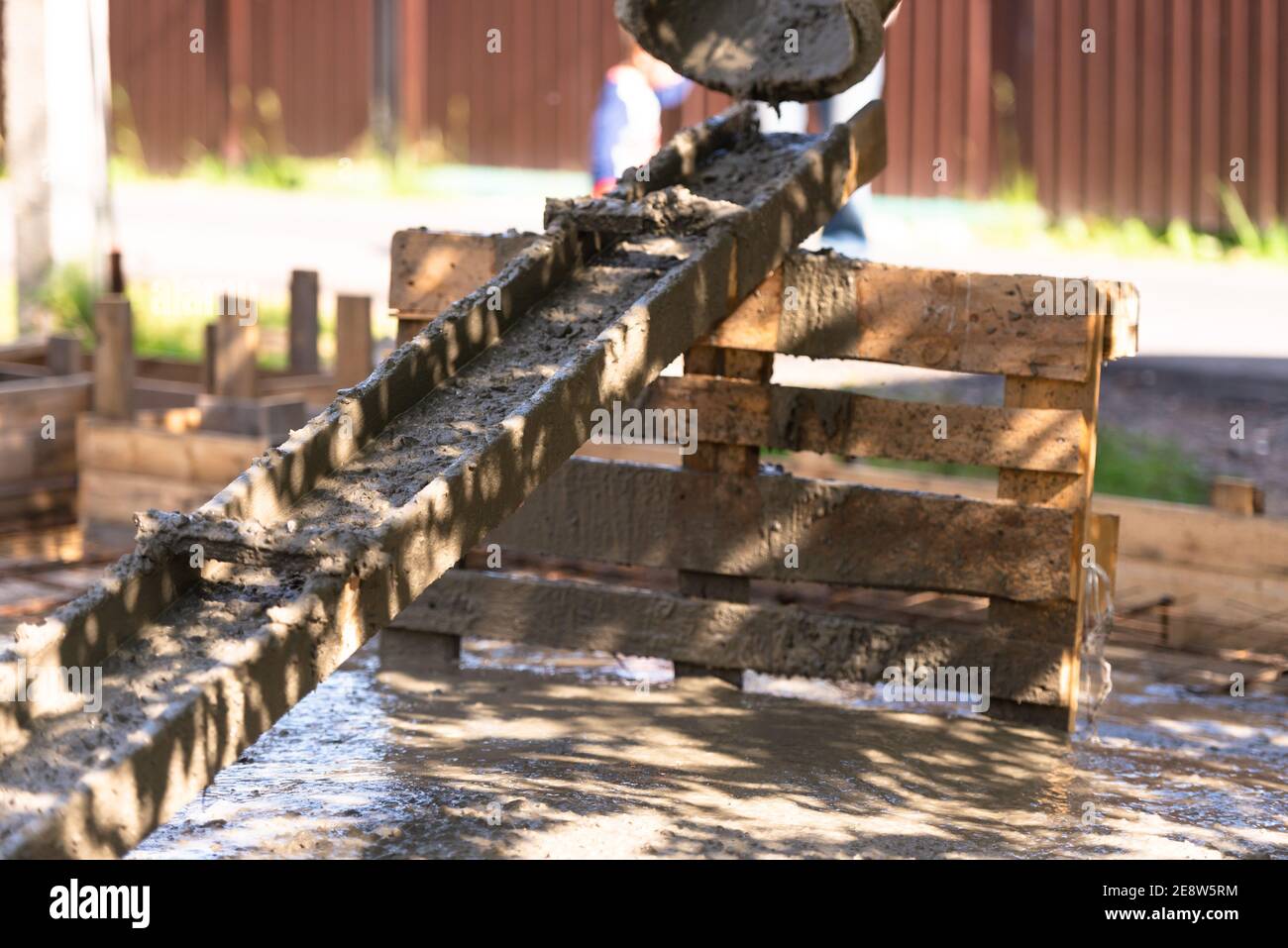 Self-made chute for concreting works. Concrete pours down a wooden ...