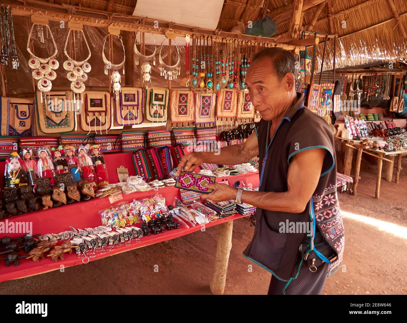 An Akha hill tribe man is offering his merchandise in the form of ...