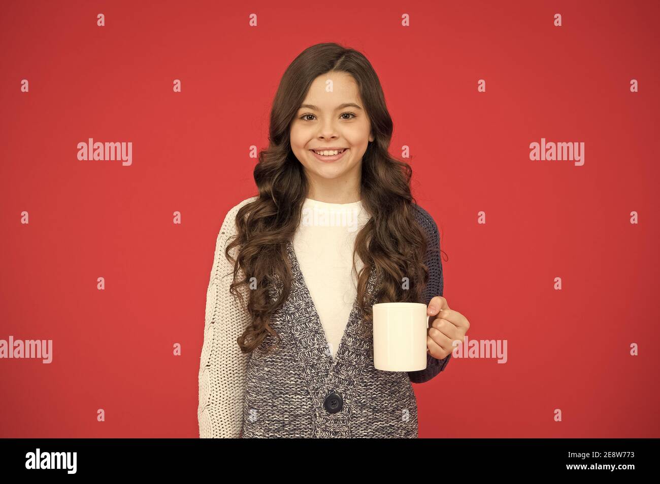 Good morning. Drink enough water. Girl kid hold mug red background ...