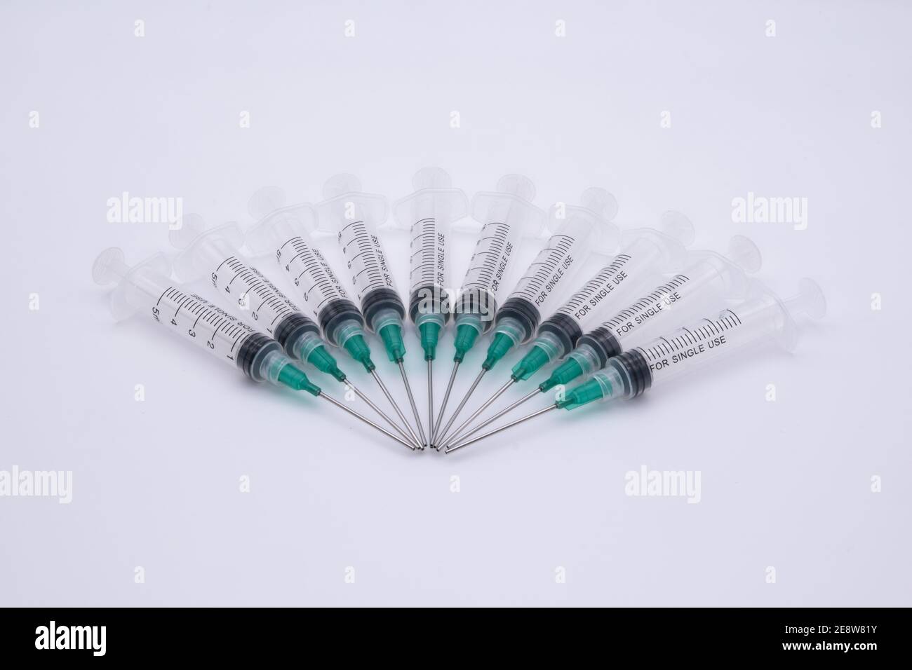 clear plastic syringes with needles isolated against a white background ...