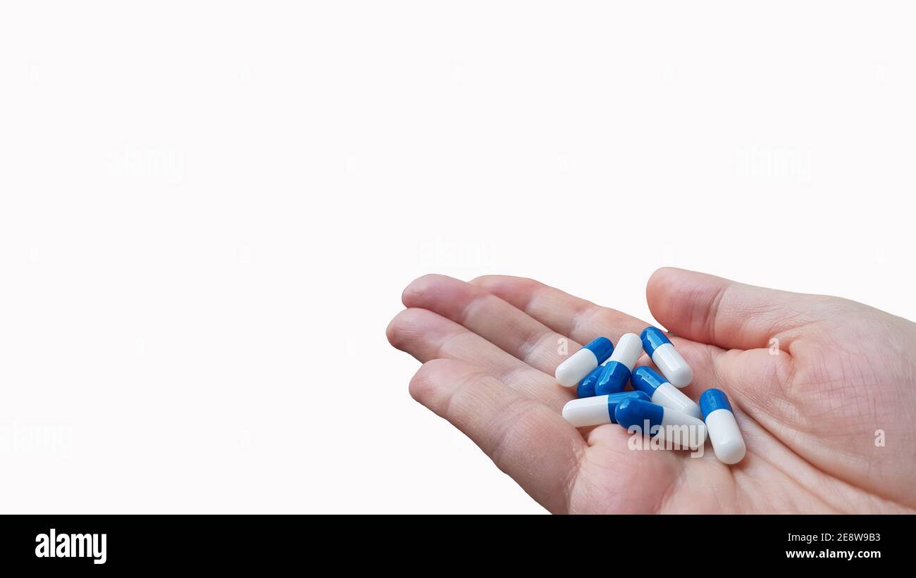 Hand holding capsules on white background Stock Photo - Alamy