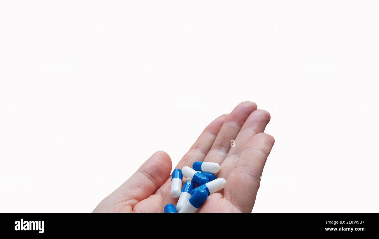 Hand holding capsules on white background Stock Photo - Alamy