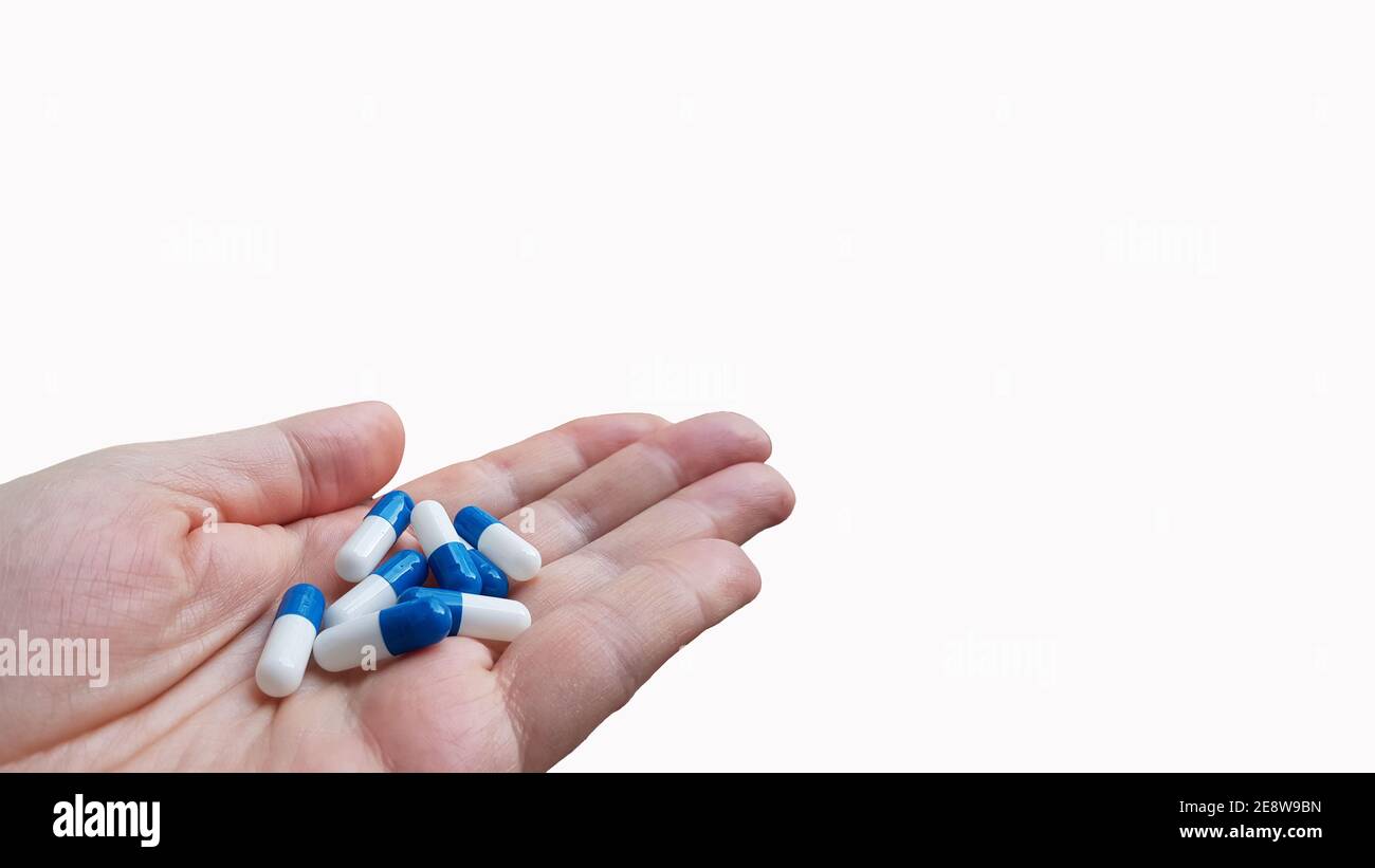 Hand holding capsules on white background Stock Photo - Alamy