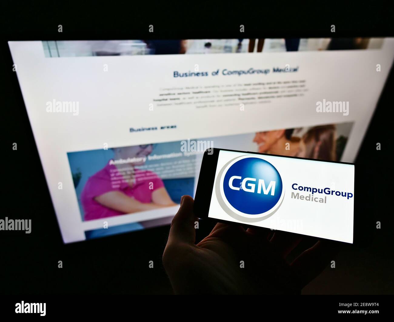 Person holding cellphone with business logo of software developer ...