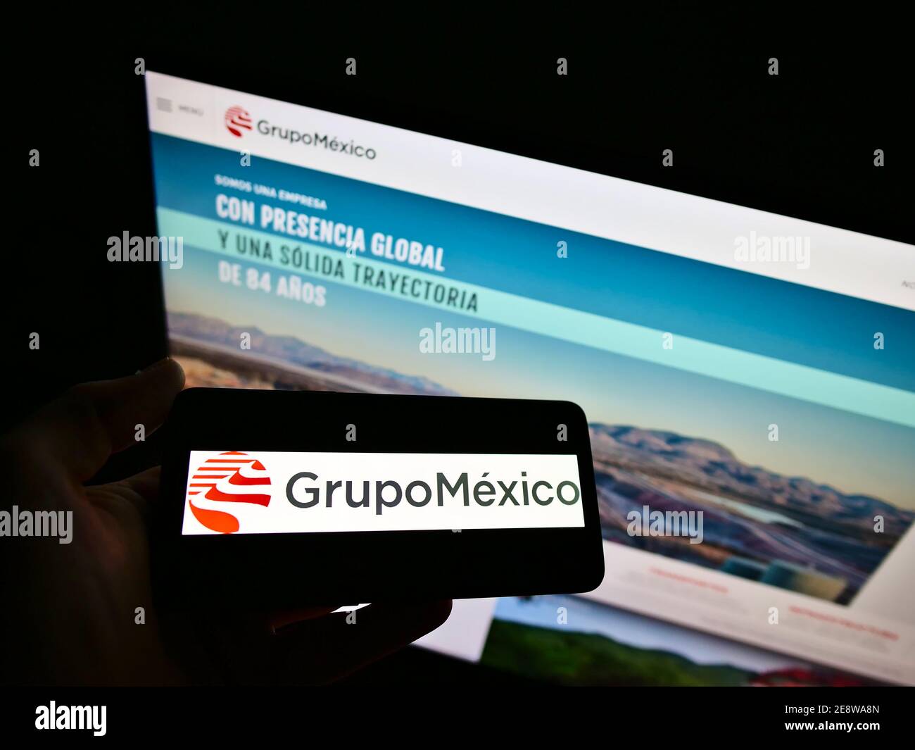 Person holding mobile phone with logo of Mexican mining and ...