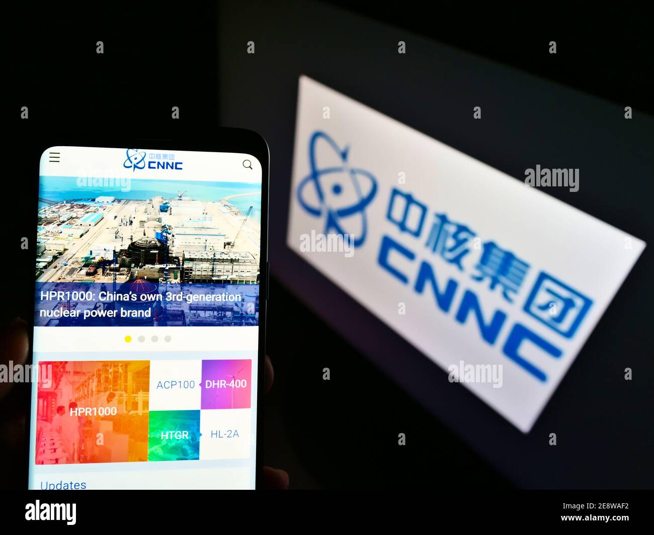 Person holding cellphone with logo of China National Nuclear ...