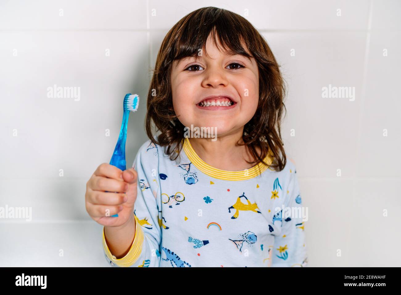 child very cheerful after brushing teeth with a toothbrush with pajamas ...