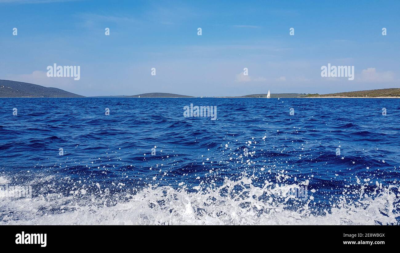 Splashing foaming water with a blue sea during the daytime Stock Photo ...