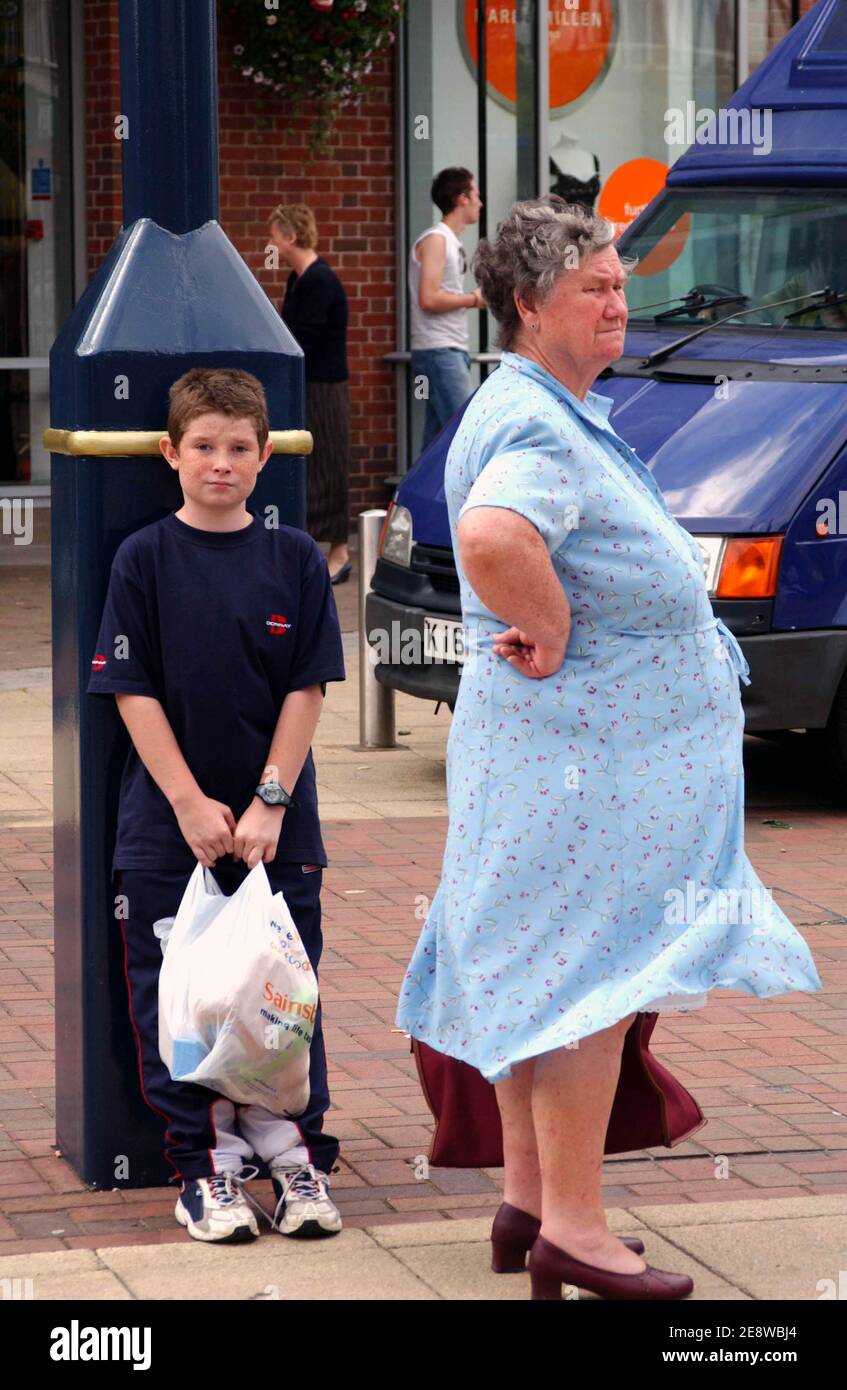 A rotund elderly woman pauses during her shopping in a pedestrian ...