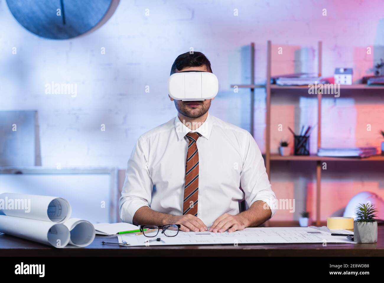 architect in vr headset sitting at workplace near blueprints Stock ...