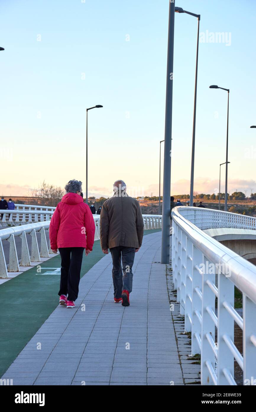 Couples walking on the bridge at sunset. Daily exercise, healthy living ...