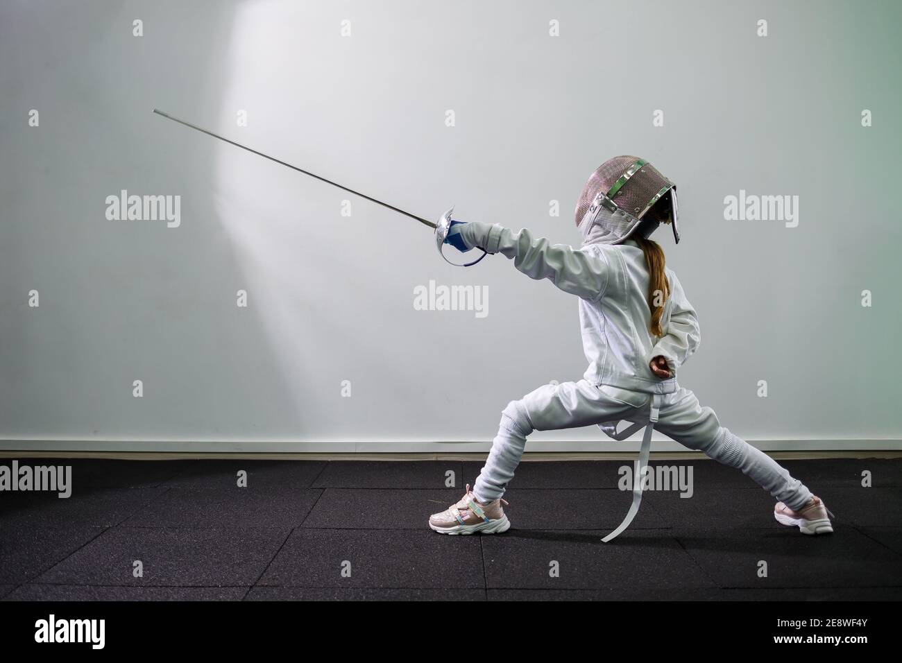 Children lunge on swords. A child in a class at a fencing school Stock ...