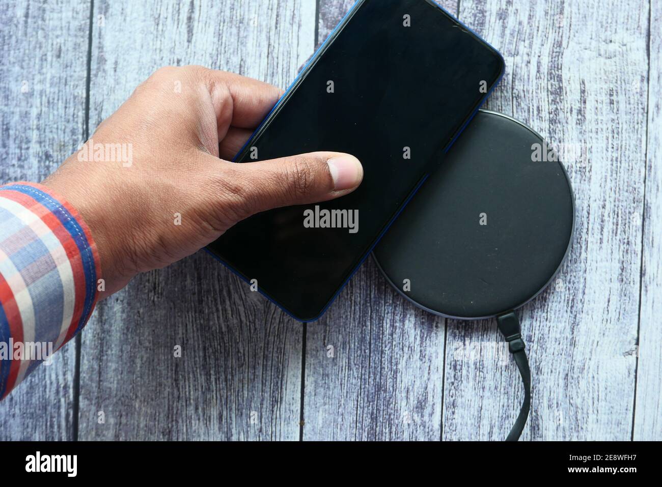 charging Smartphone using Wireless Charging Pad, top view Stock Photo ...