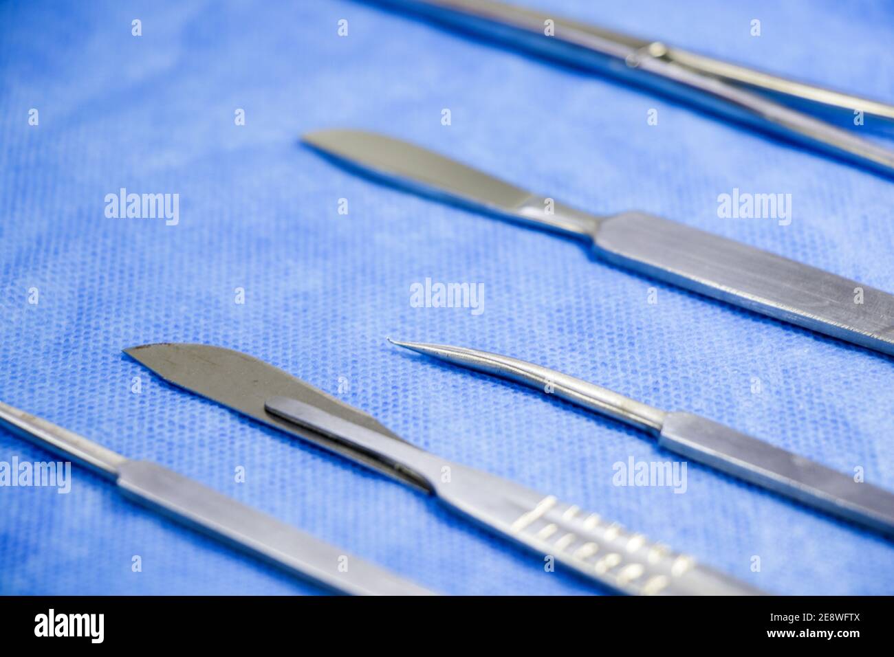 Top view of medical scalpels on a blue fabric surface Stock Photo - Alamy