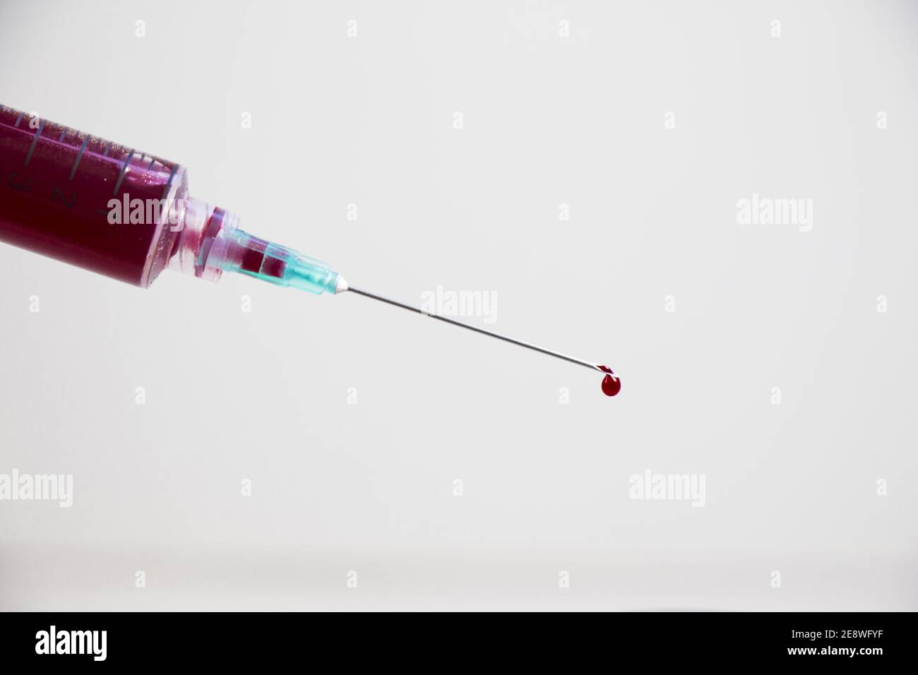 Closeup shot of a needle syringe with blood on the bevel isolated on ...