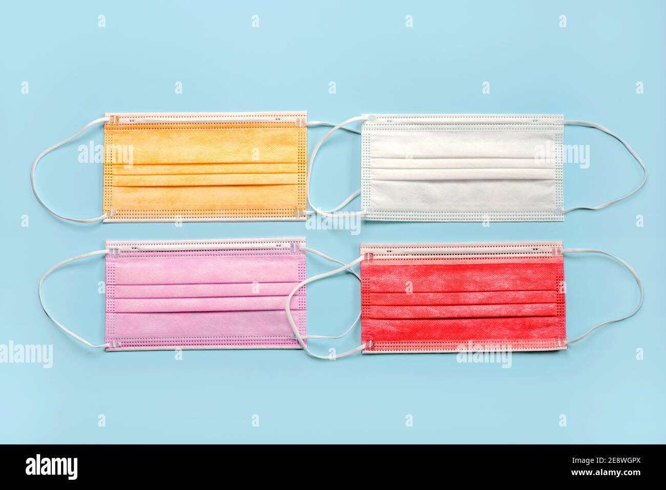 Colored protective surgical masks on blue background.Covid 19 concept ...