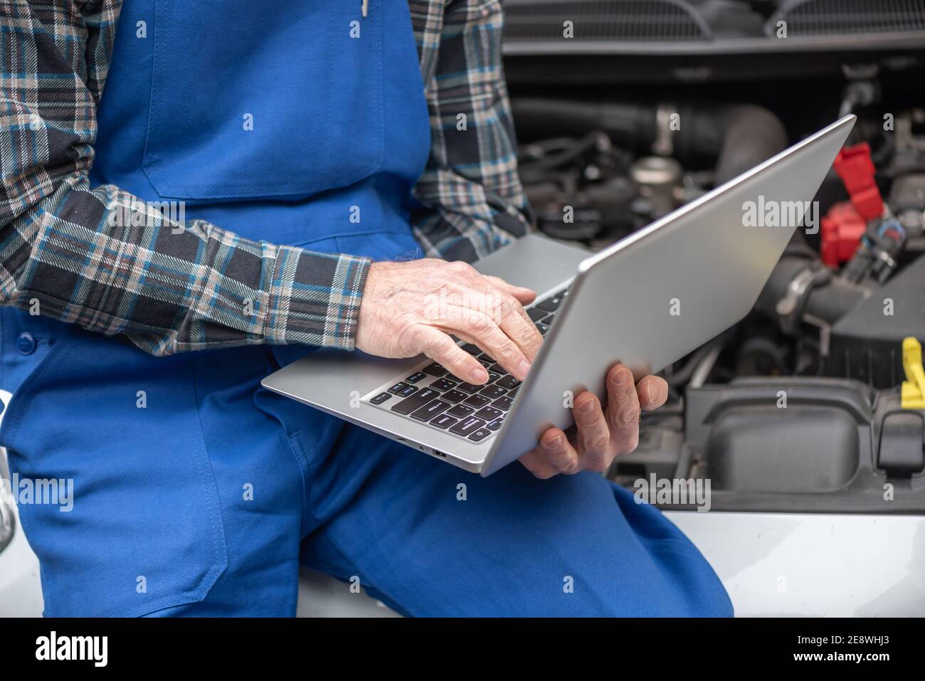 Car mechanic using laptop for checking car engine Stock Photo - Alamy