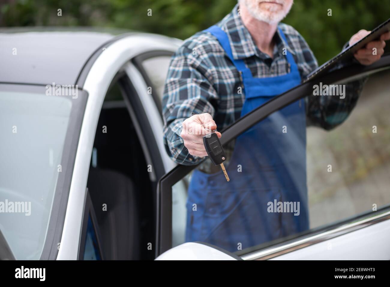 Car mechanic delivering car keys after car engine checking Stock Photo ...