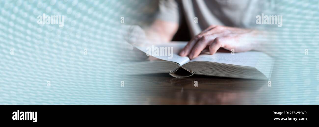 Man sitting at a table reading a book. panoramic banner Stock Photo - Alamy