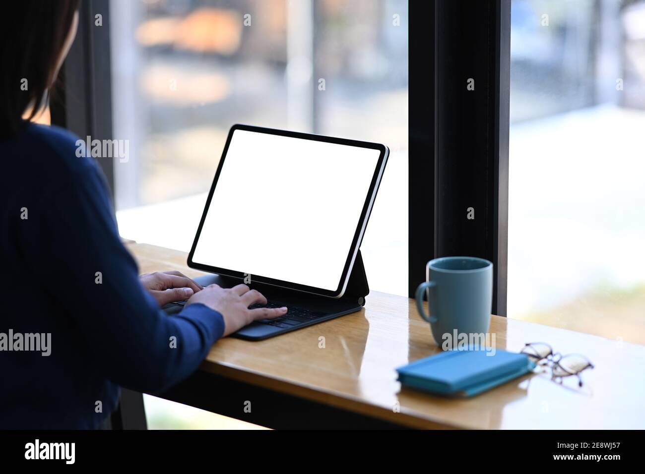 Side view of concentrated female freelance working with digital tablet ...