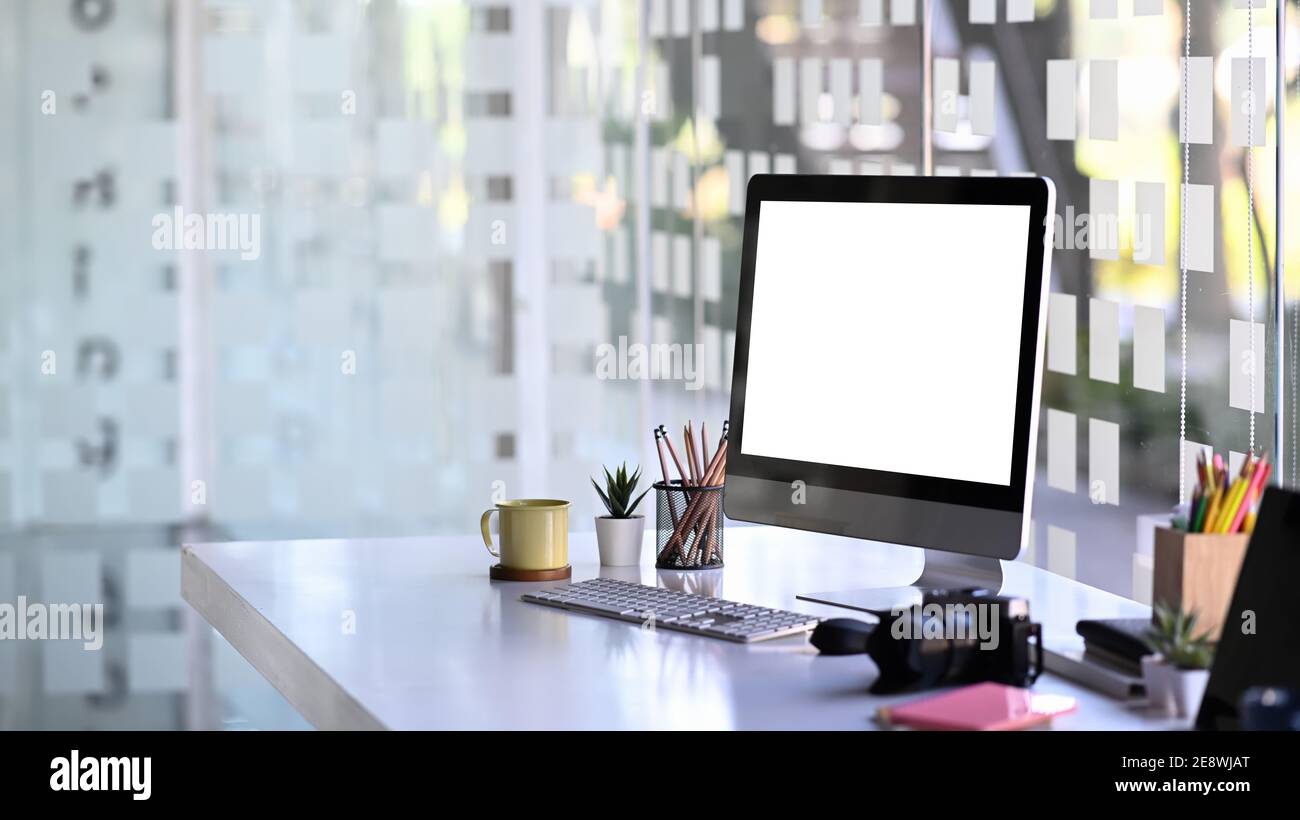 Mock up computer with white screen, camera and office supplies on photographer workstation Stock ...