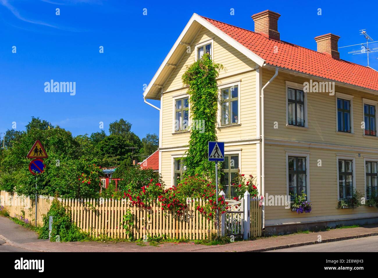 Residential house on a street corner with blooming roses Stock Photo ...