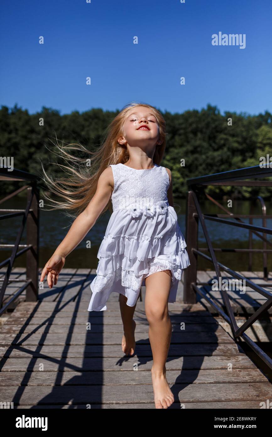 A Six Year Old Girl Is Wearing A White Dress Beautiful Long Hair Walk