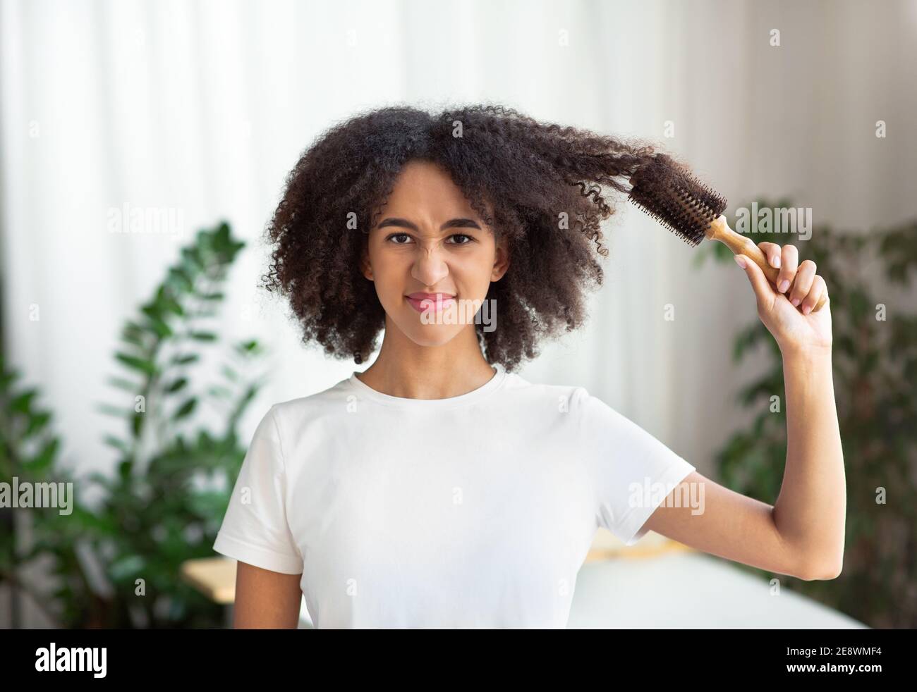 Unhappy african american woman brush tangled, damaged, dry hair Stock ...