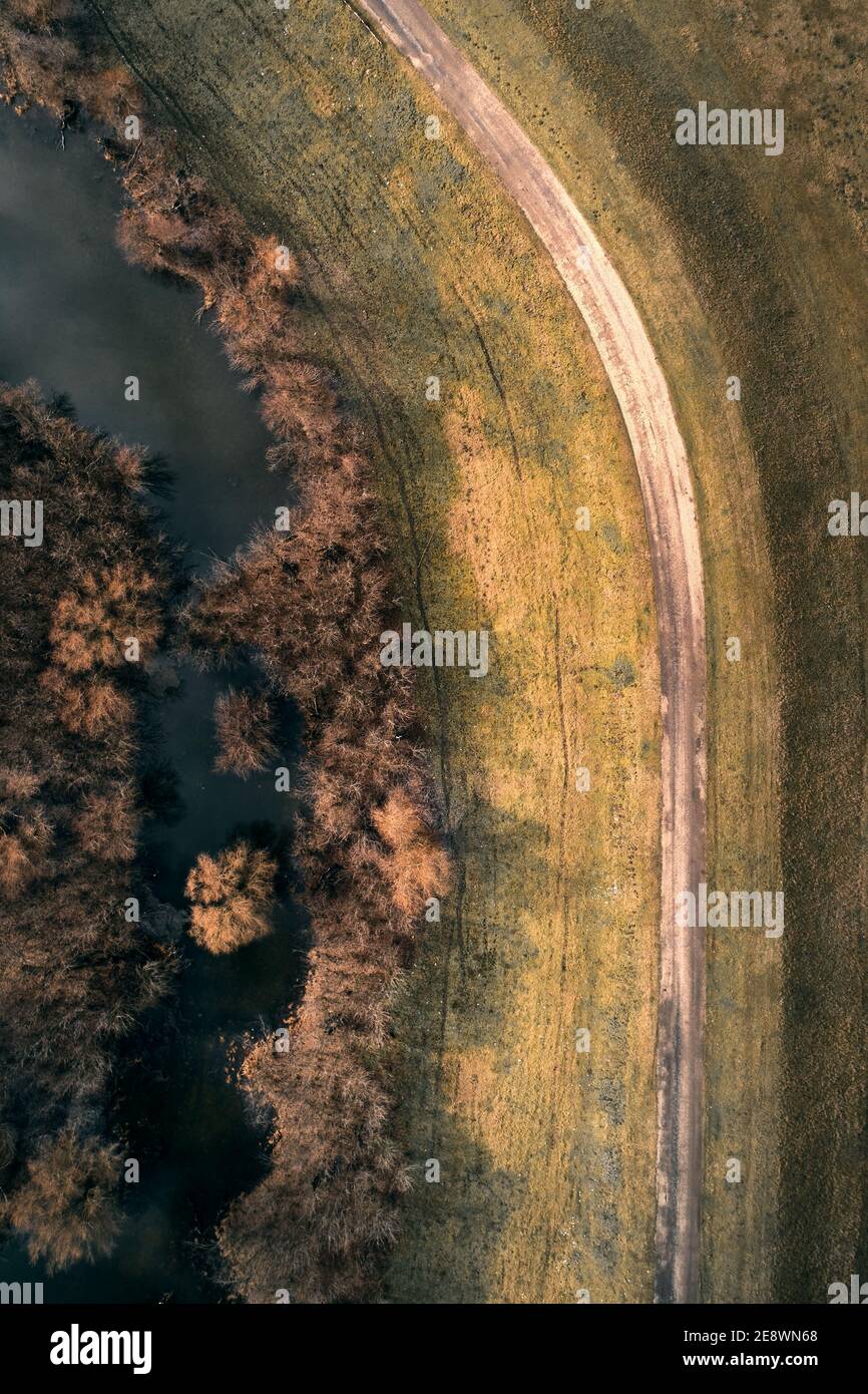 Aerial view of winding road and swampy river oxbow landscape, top view ...
