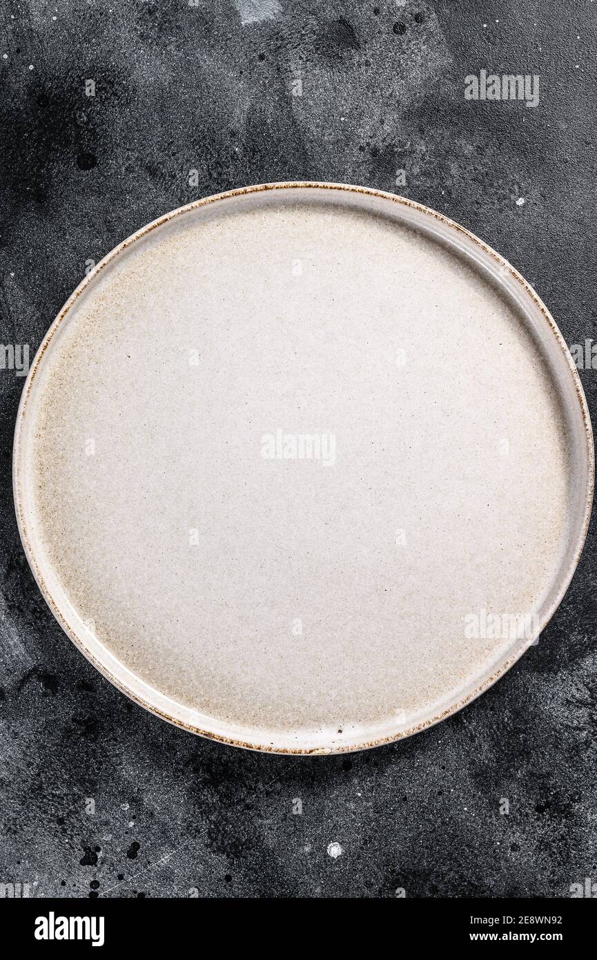 White empty round plate, restaurant background. Black background. Top ...