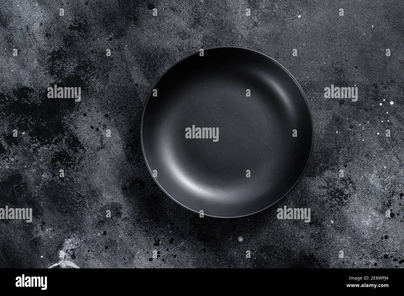 Black plate on textured black background. Top view. Copy space Stock ...