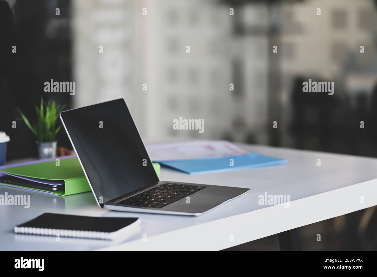 Side view of mock up laptop computer and document file on conference ...