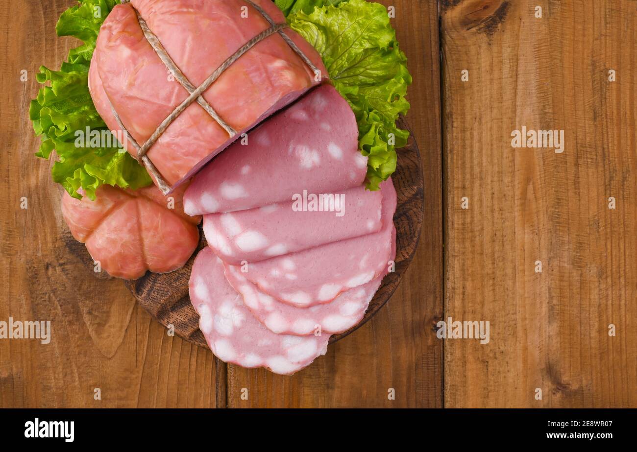 big Italian Whole block of mortadella on a wooden plate. Traditional ...